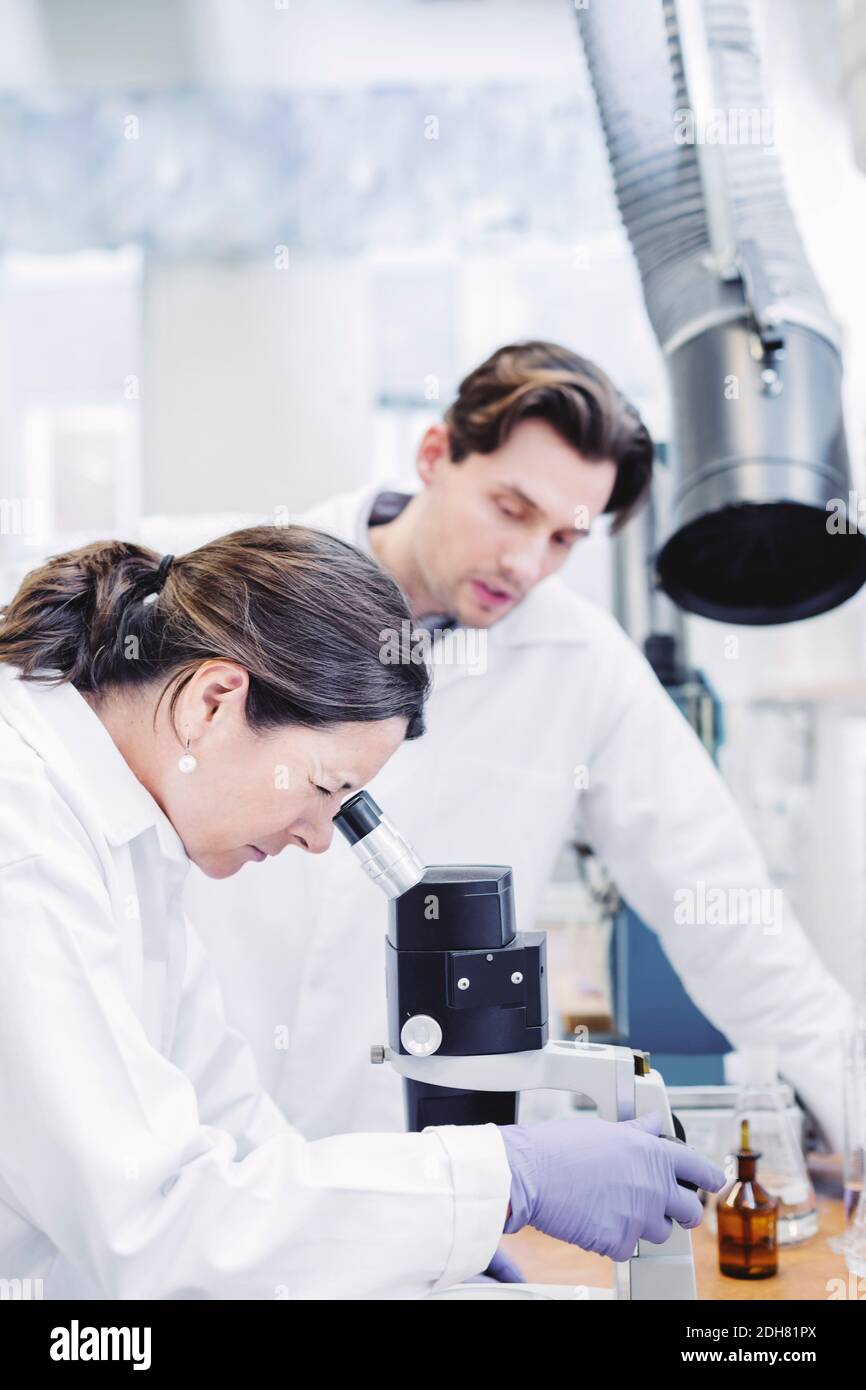 Female scientist using microscope at laboratory Stock Photo - Alamy