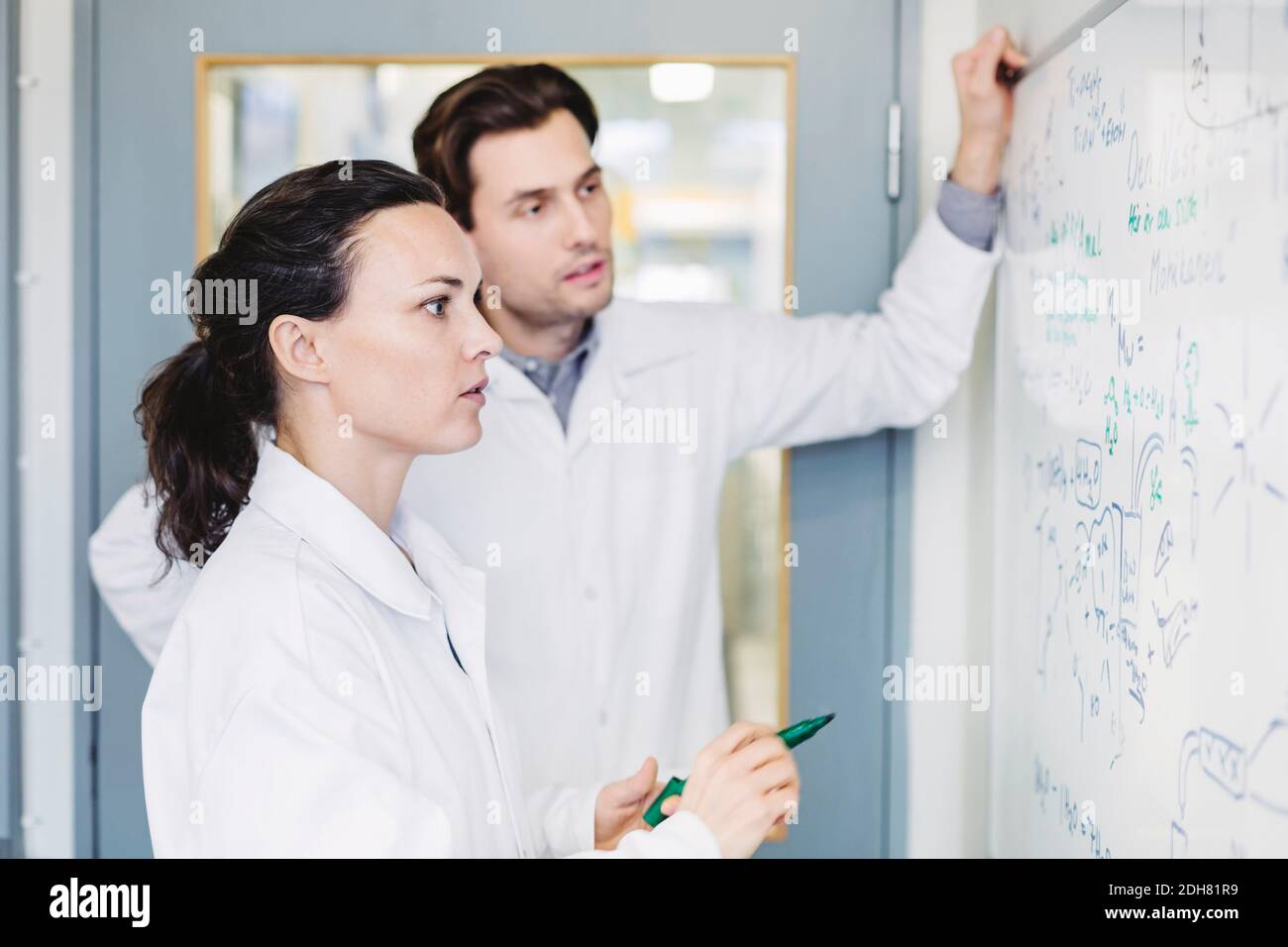 Scientists discussing plan on whiteboard in laboratory Stock Photo - Alamy