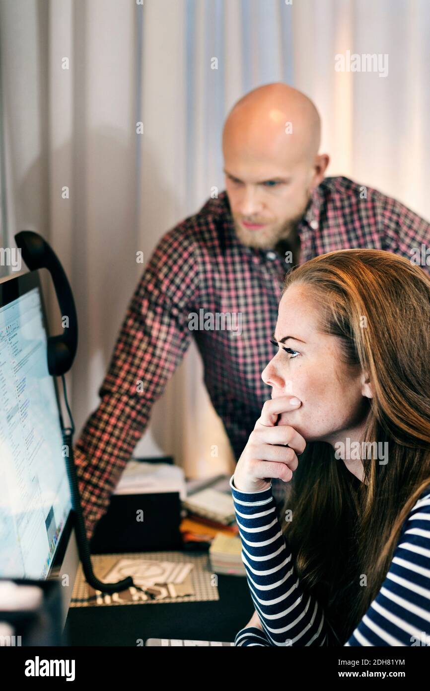 Business people looking at computer in office Stock Photo - Alamy