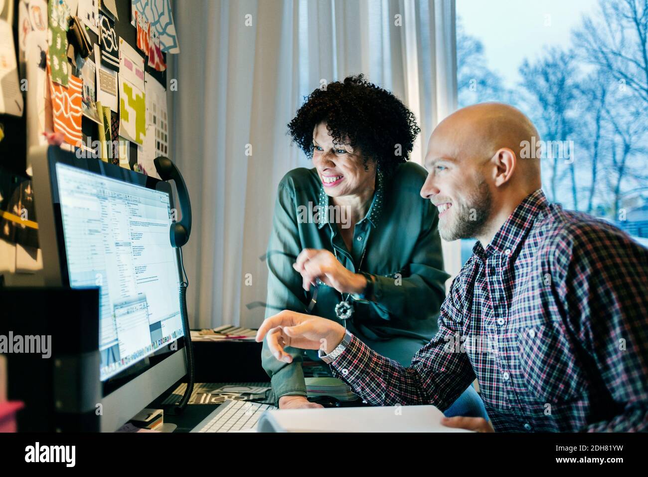 Happy business people working on computer in office Stock Photo - Alamy