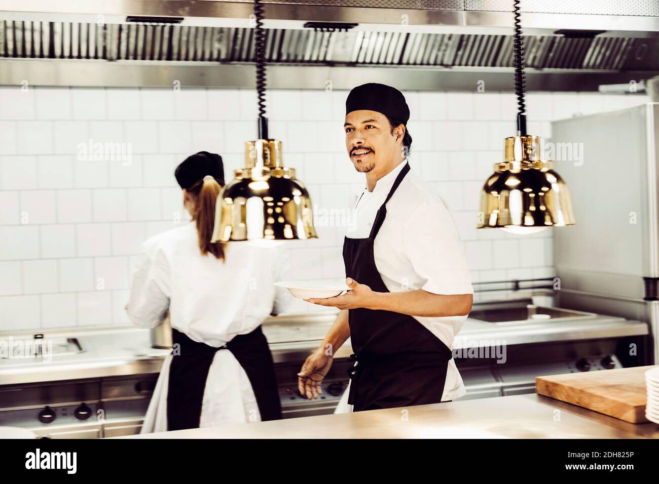 Chefs working in commercial kitchen Stock Photo - Alamy