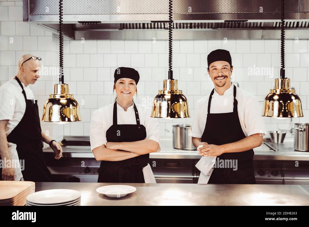 Portrait of happy chefs standing at commercial kitchen counter Stock ...