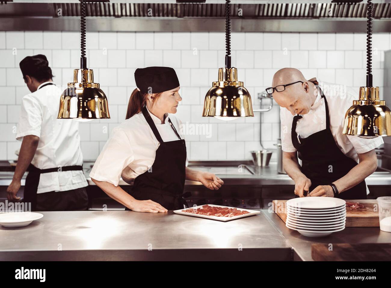 Male and female chefs working in commercial kitchen Stock Photo - Alamy
