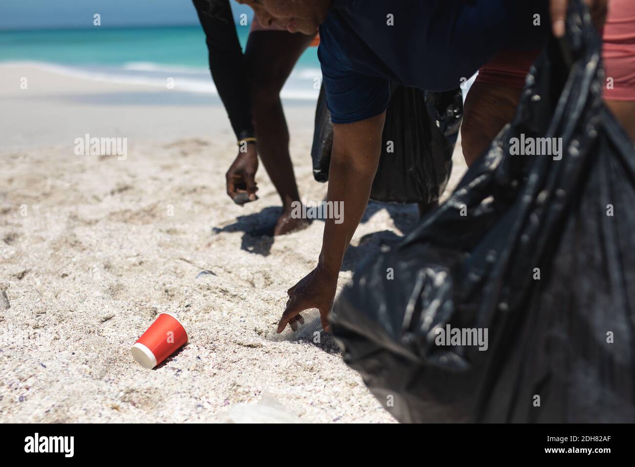 Old couple collecting waste at the beach Stock Photo - Alamy