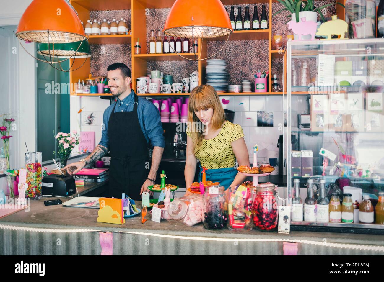 Man and woman working at cafe counter Stock Photo - Alamy