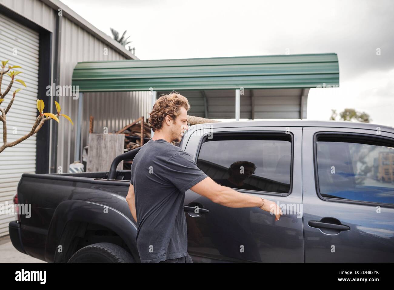 Carpenter entering pick-up truck outside workshop Stock Photo - Alamy