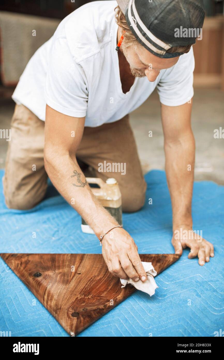 Carpenter polishing triangle shaped wood at workshop Stock Photo - Alamy