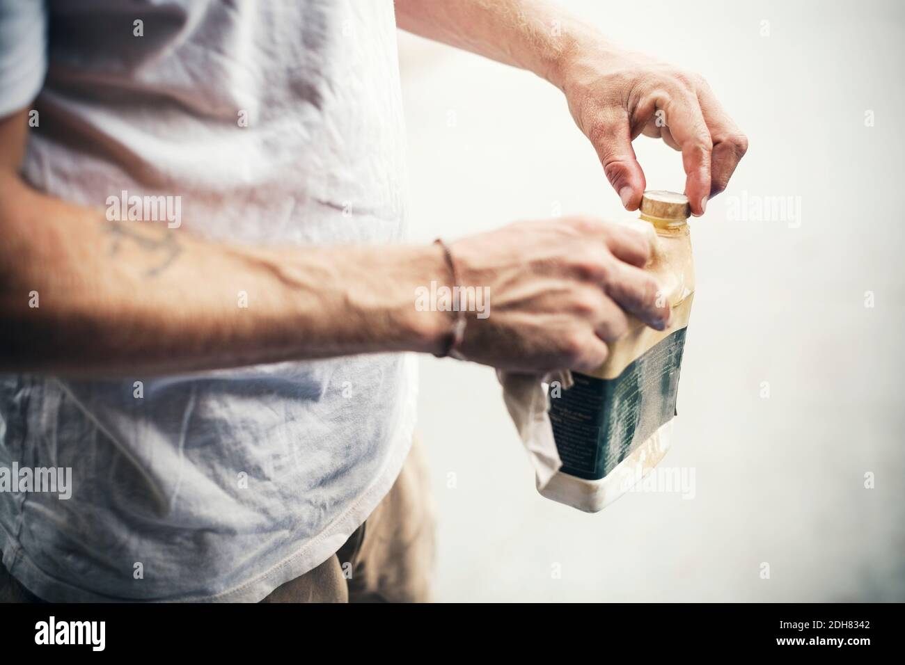 Midsection of carpenter closing oil can at workshop Stock Photo - Alamy