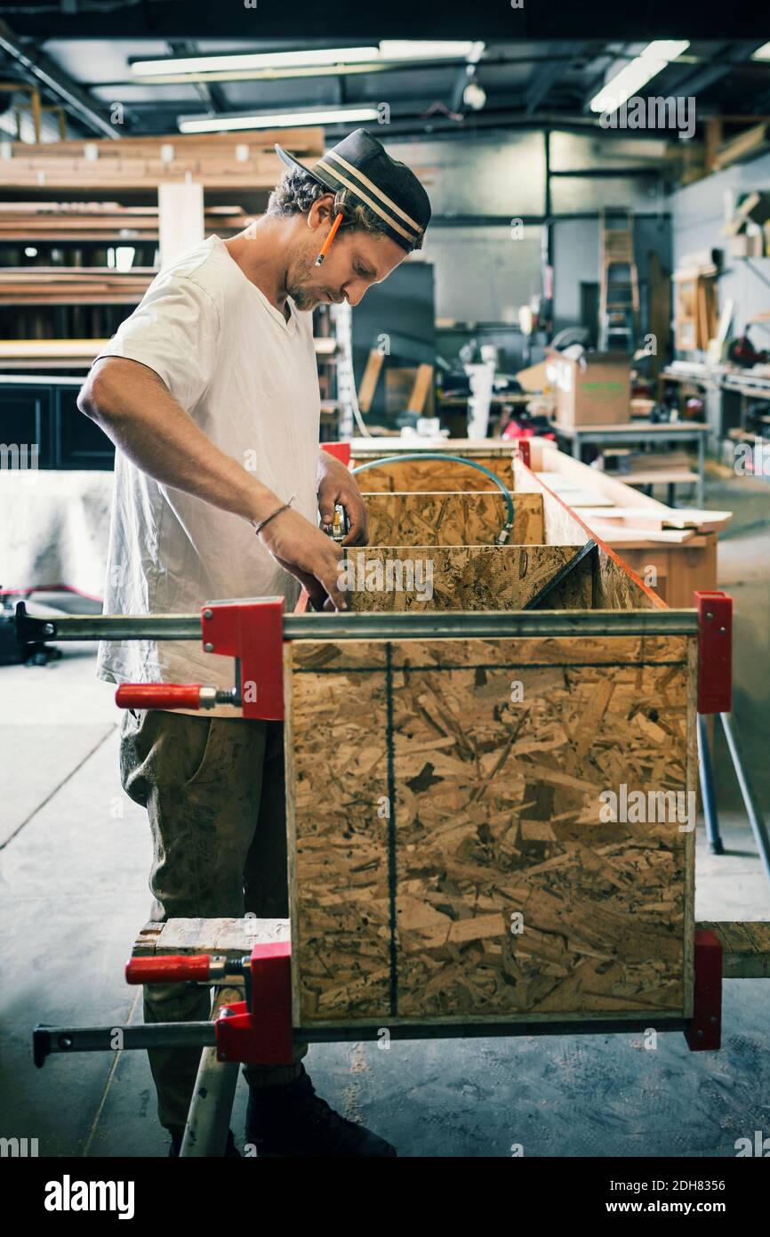 Side view of carpenter making furniture at workshop Stock Photo - Alamy