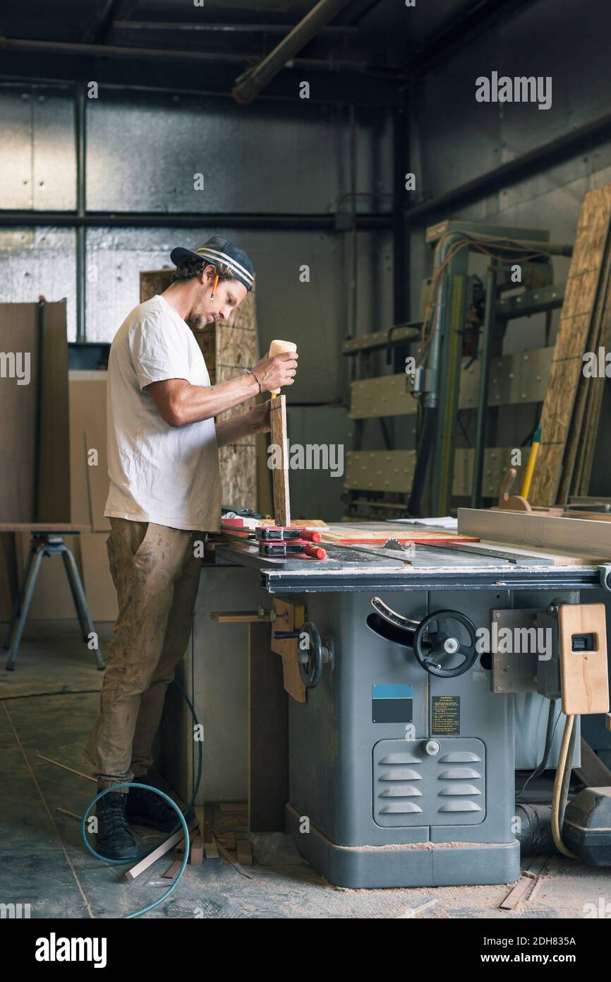 Side view of carpenter working at workshop Stock Photo - Alamy