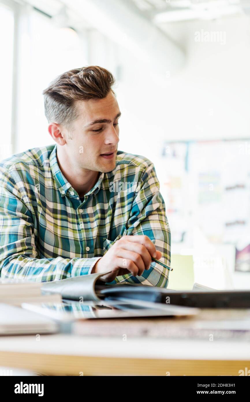 Young man sitting and studying in classroom Stock Photo - Alamy
