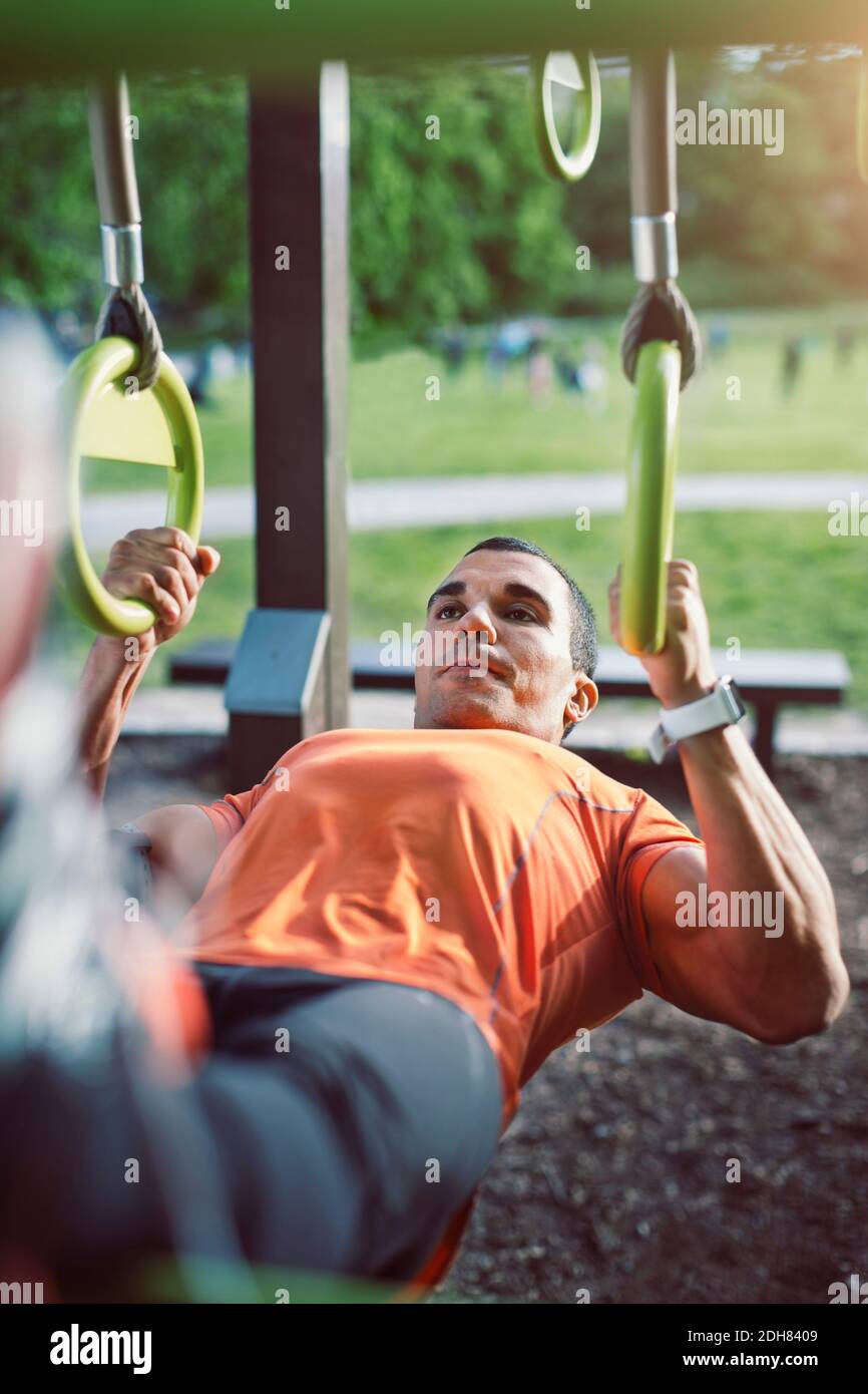 Man hanging with rings and doing chin-ups Stock Photo - Alamy