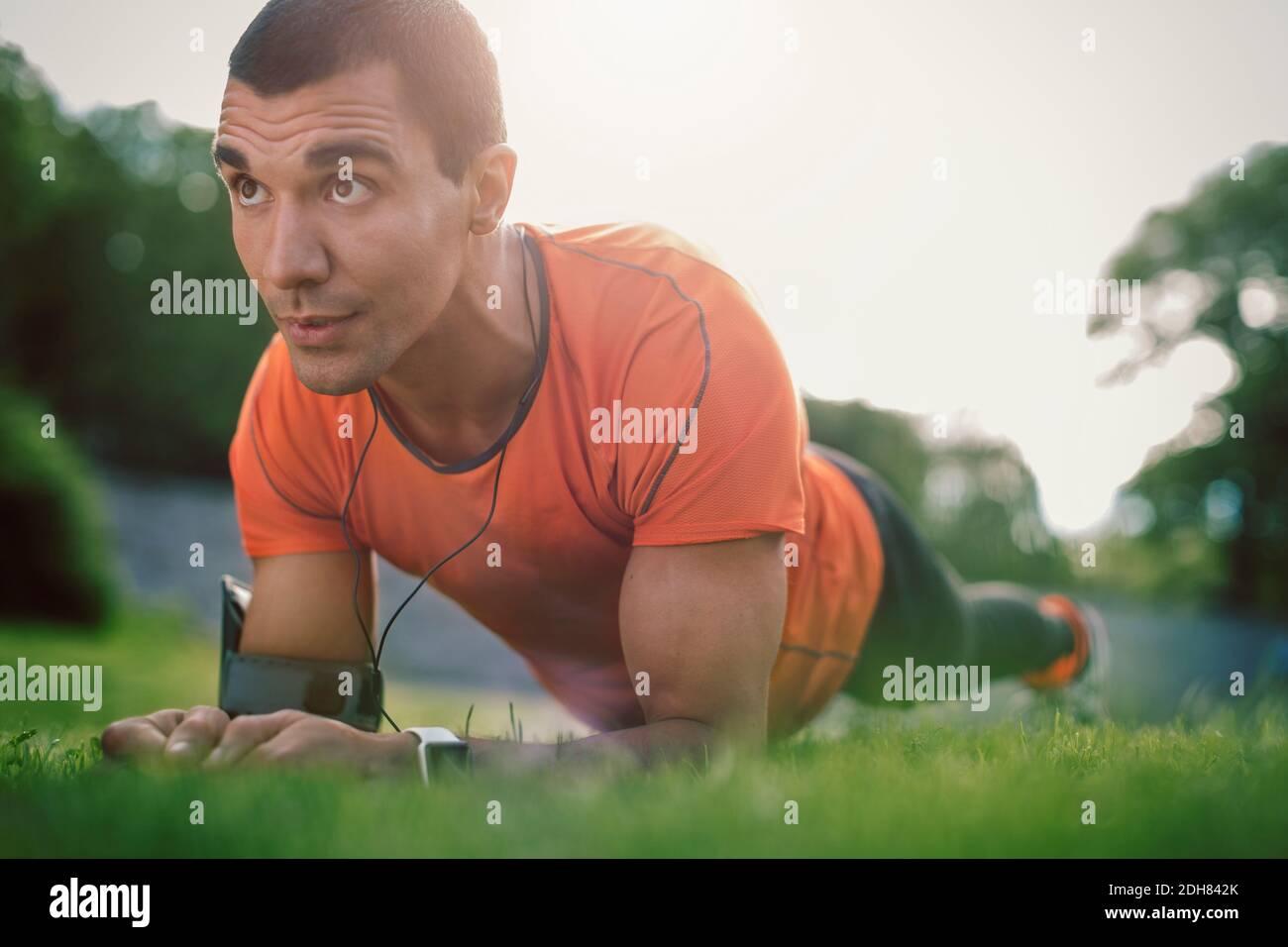Man in plank position on grassy field at park Stock Photo - Alamy
