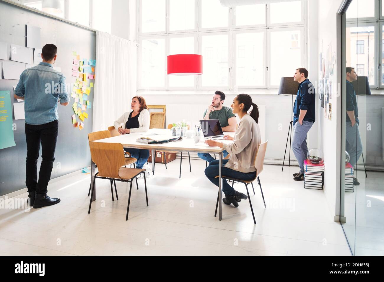 Businessman giving presentation to colleagues in conference room Stock ...