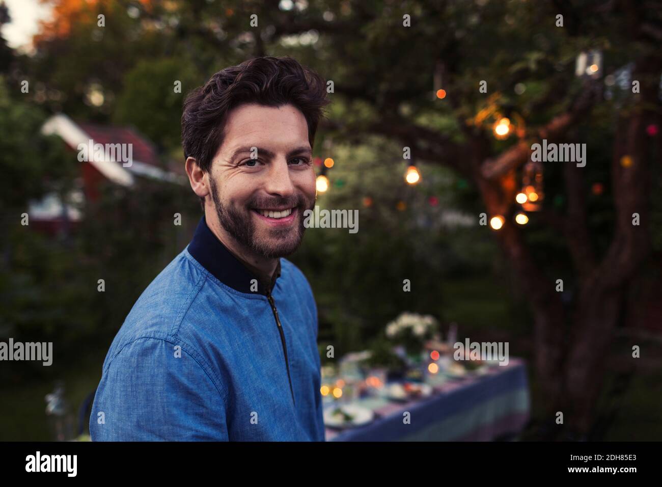 Portrait of happy man standing by dinner table at yard Stock Photo - Alamy