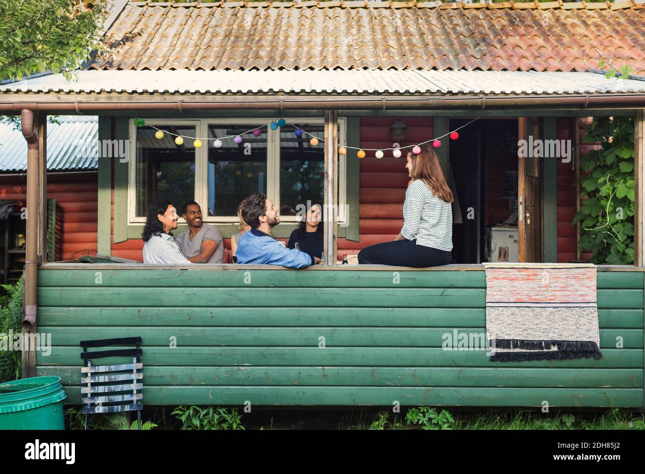 Happy multi-ethnic friends enjoying party in log cabin Stock Photo - Alamy