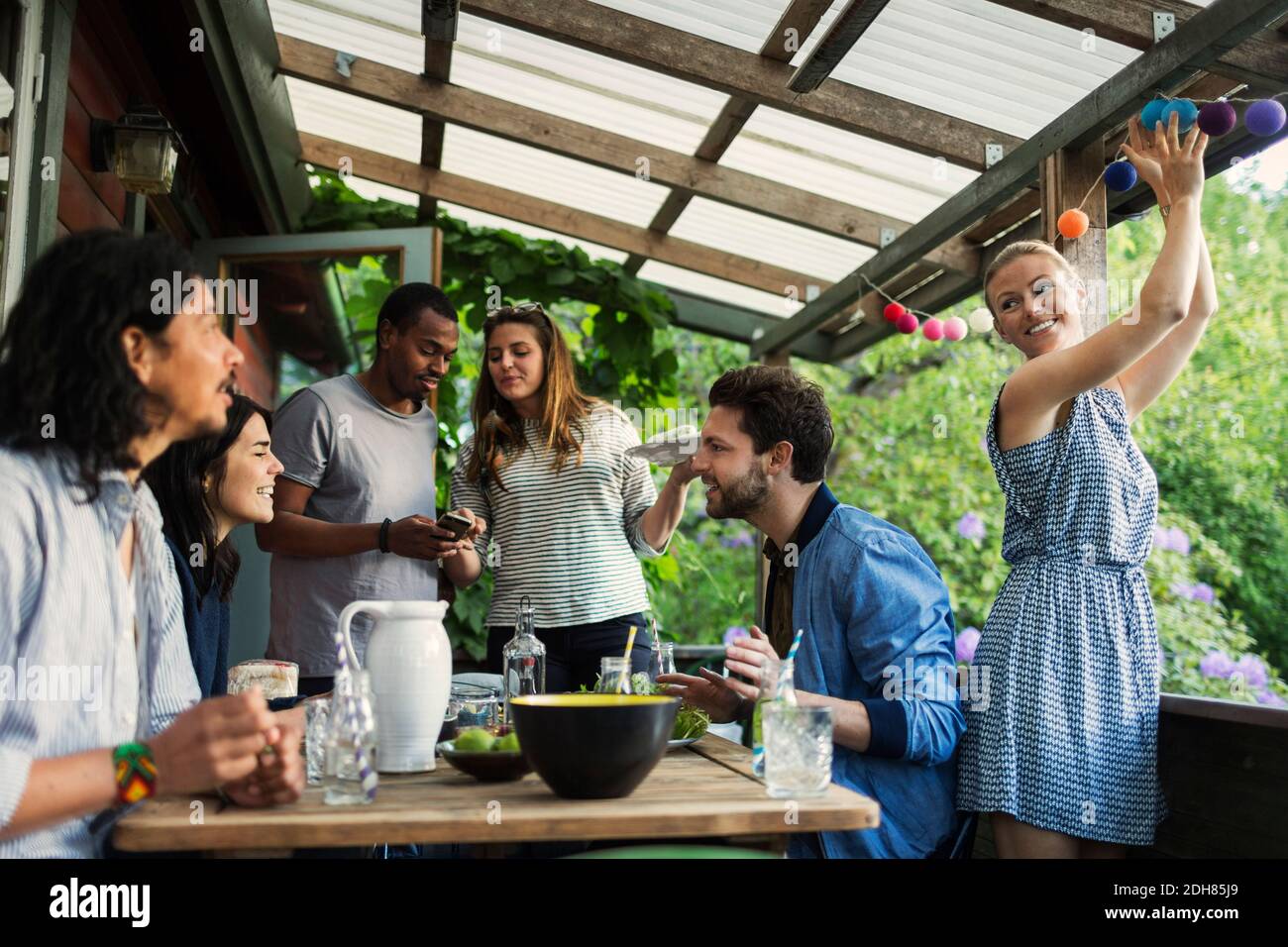 Happy friends enjoying summer party in log cabin Stock Photo - Alamy