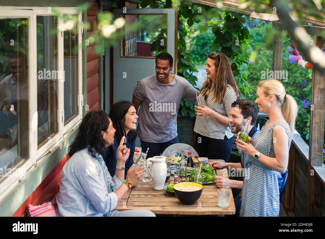 High angle view of happy multi-ethnic friends enjoying party at log ...