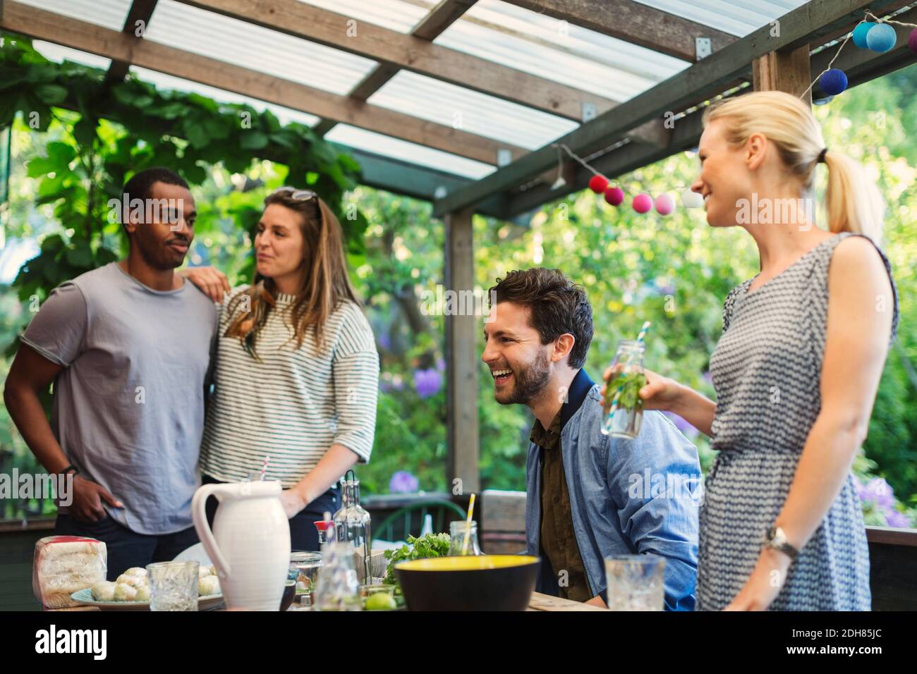 Multi-ethnic couple enjoying summer party on porch in log cabin Stock ...