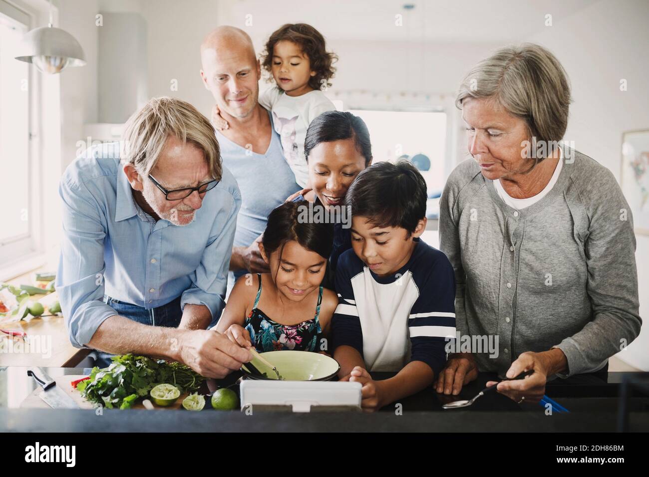 Multi-ethnic family preparing food at kitchen counter Stock Photo - Alamy