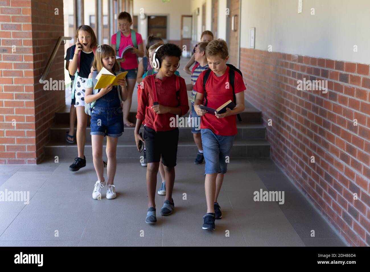 Group of school pupils walking in an outdoor corridor at elementary ...