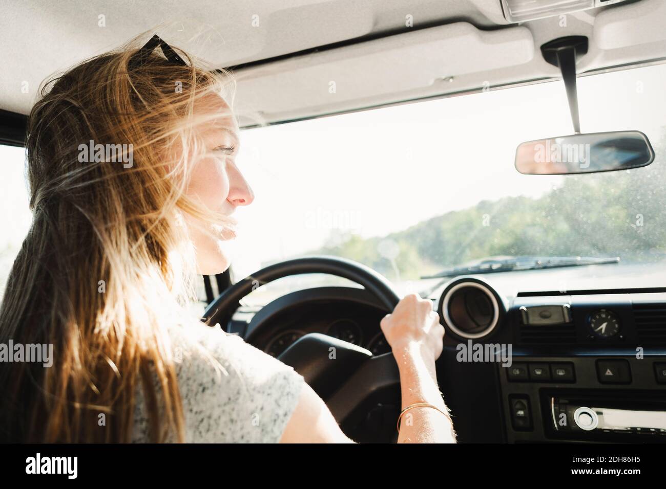 Rear view of wonderlust woman driving car Stock Photo - Alamy