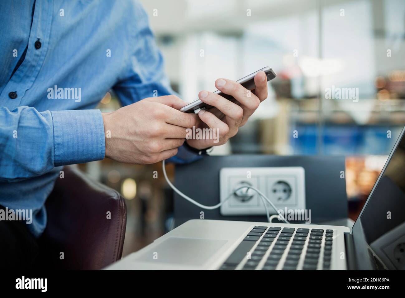 Midsection of businessman using smart phone at airport lobby Stock ...
