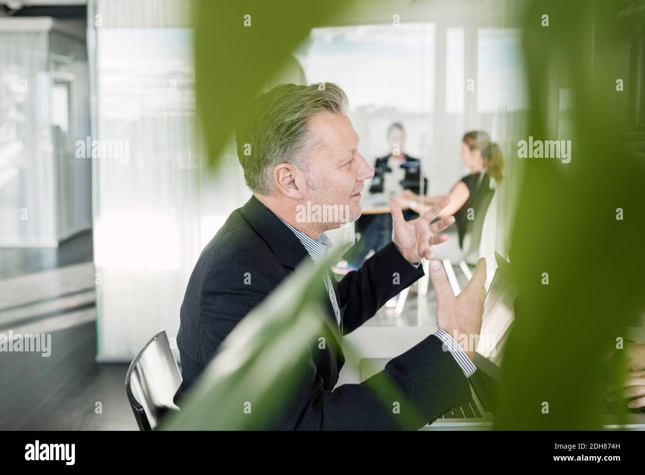 Mature businessman explaining in office Stock Photo - Alamy