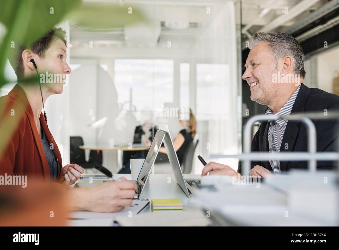 Smiling businesswoman having discussion hi-res stock photography and ...