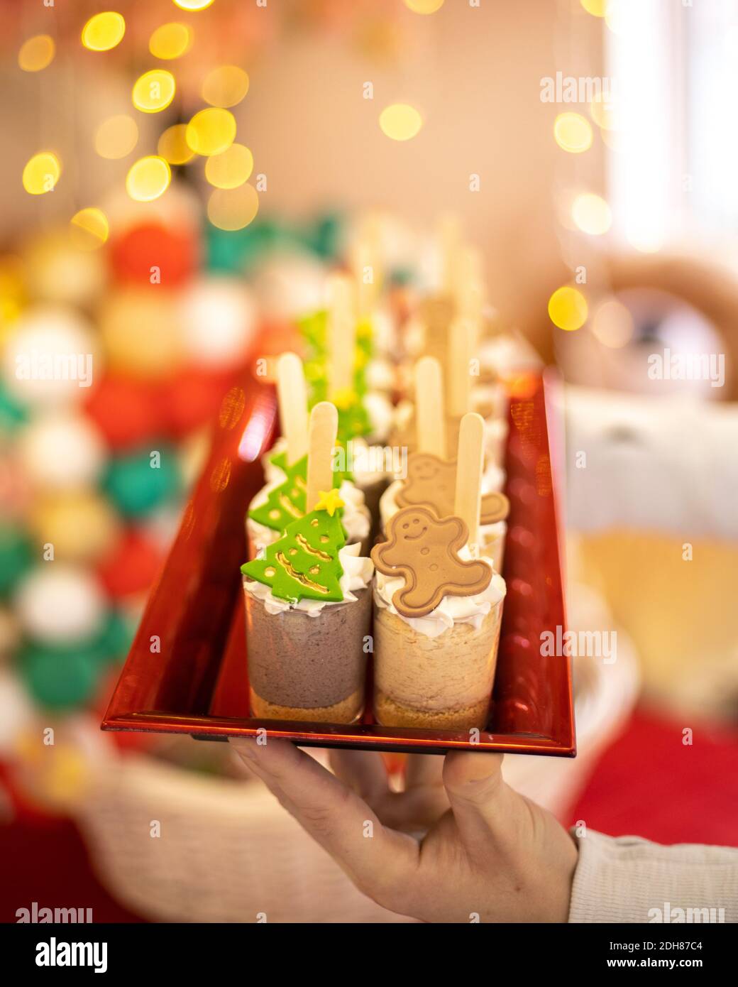 A vertical shot of Christmas desserts on a plastic tray. Colorful tasty ...