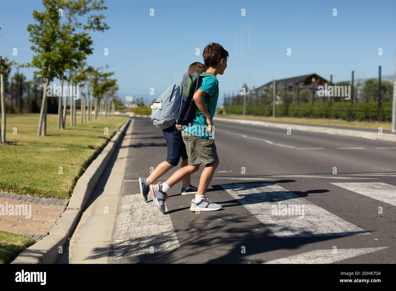 Two schoolboys crossing the road on a pedestrian crossing Stock Photo ...