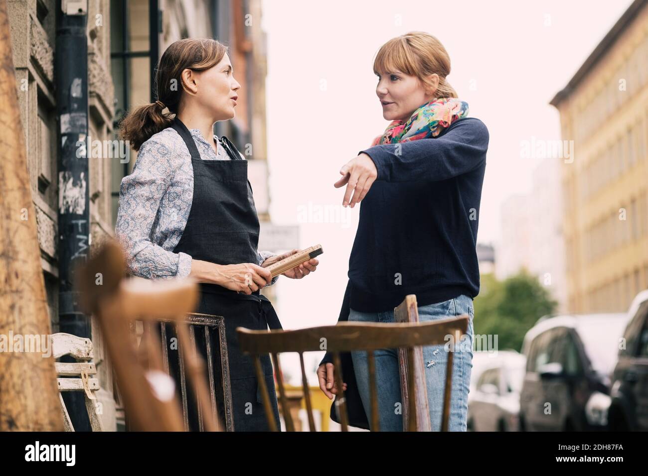 Store owner talking to customer outside hi-res stock photography and ...
