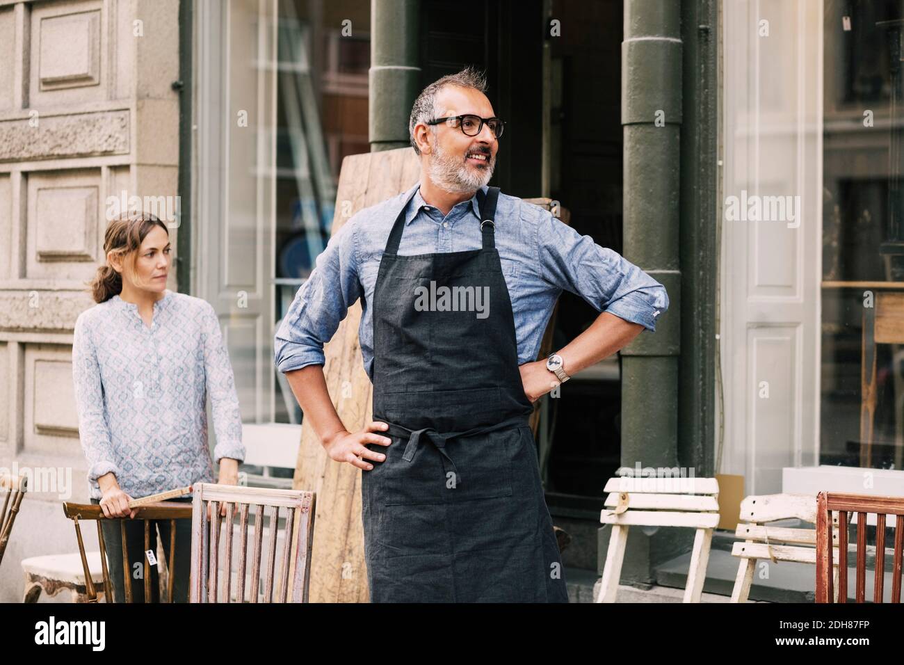 Mature male with female owners standing outside antique shop Stock ...