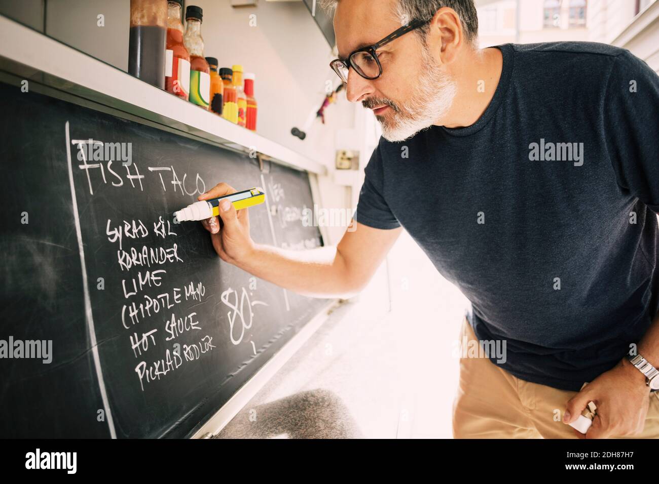 Close-up of vendor writing menu on blackboard at food truck Stock Photo ...