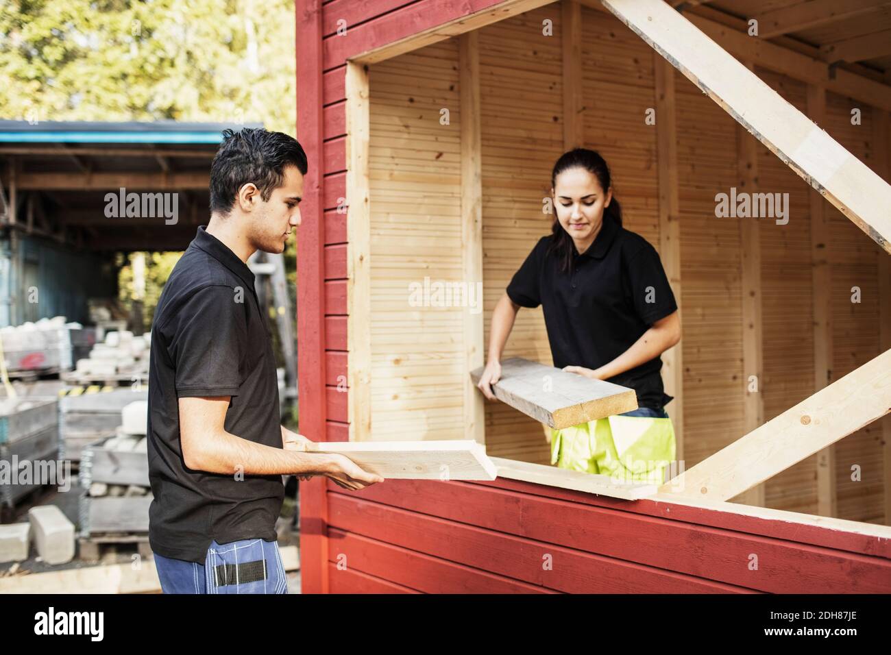 Carpentry students carrying planks while working outdoors Stock Photo ...