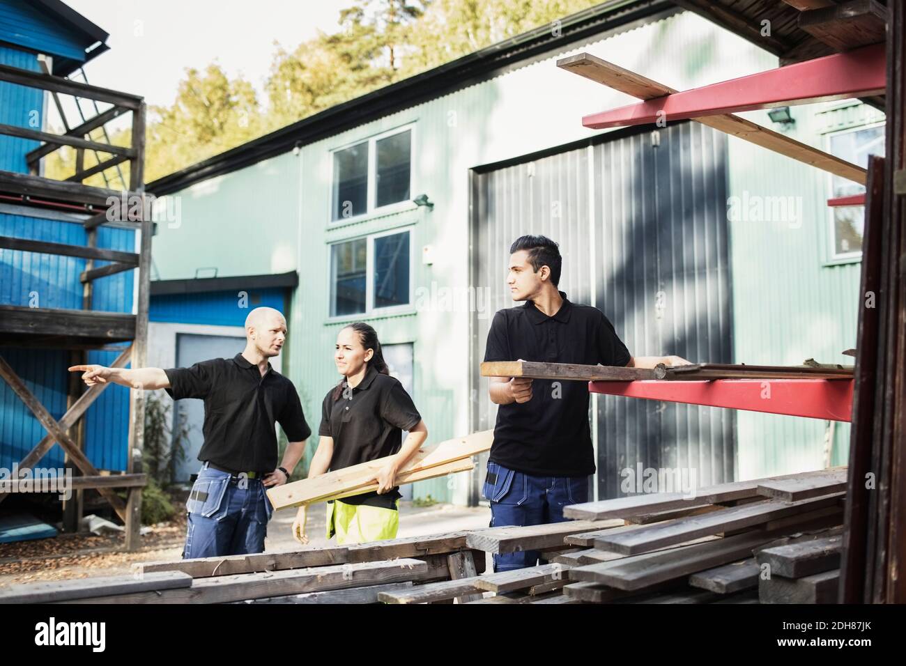 Carpentry teacher explaining students outside school Stock Photo - Alamy