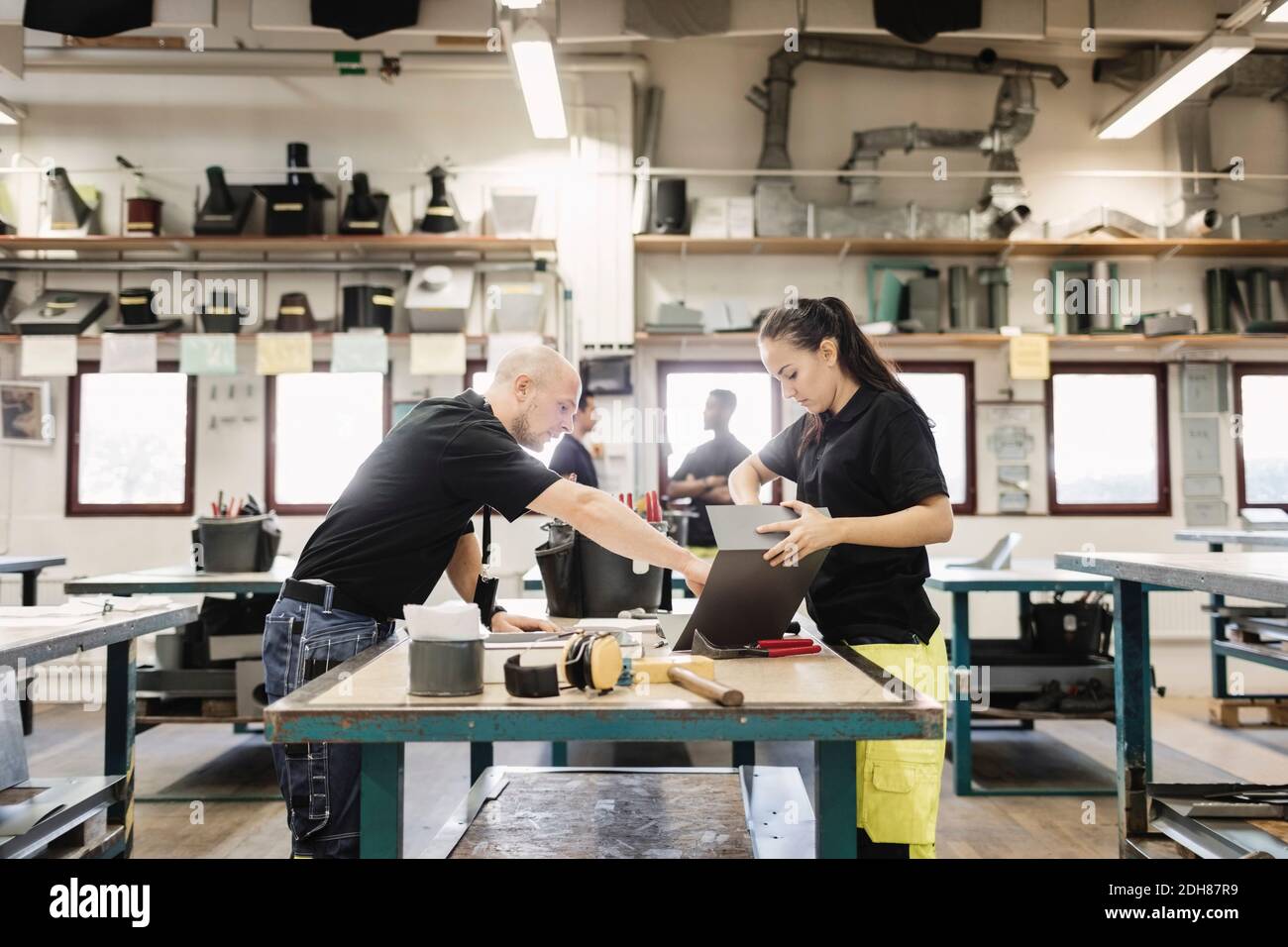 Teacher guiding high school student on project in workshop Stock Photo ...