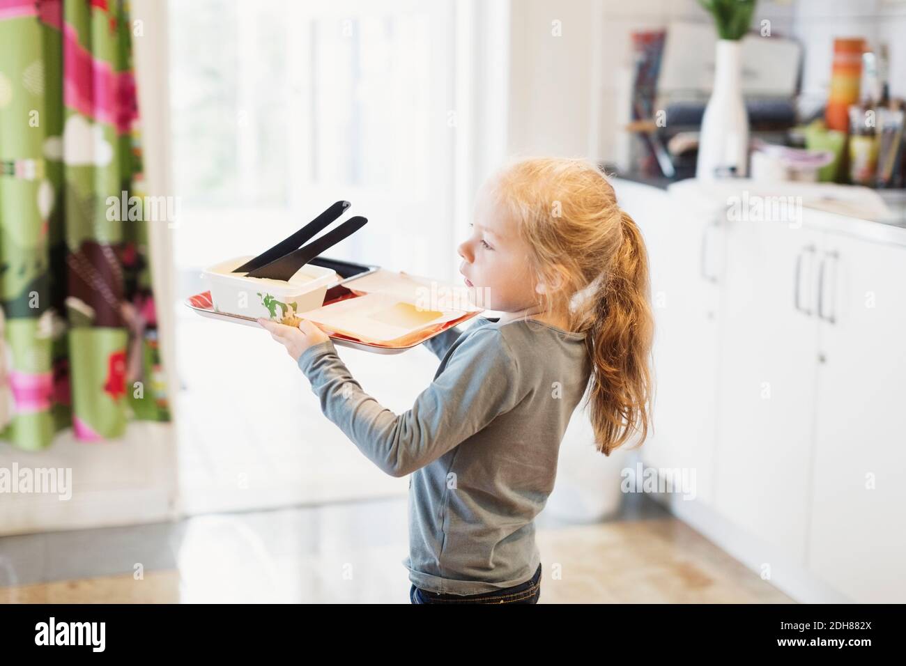 Side view of girl carrying food tray in preschool Stock Photo - Alamy