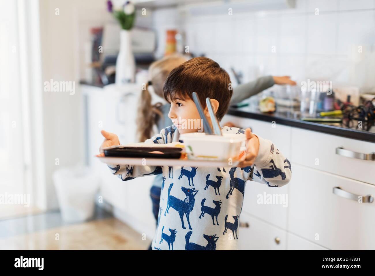 Boy carrying food tray in preschool Stock Photo - Alamy