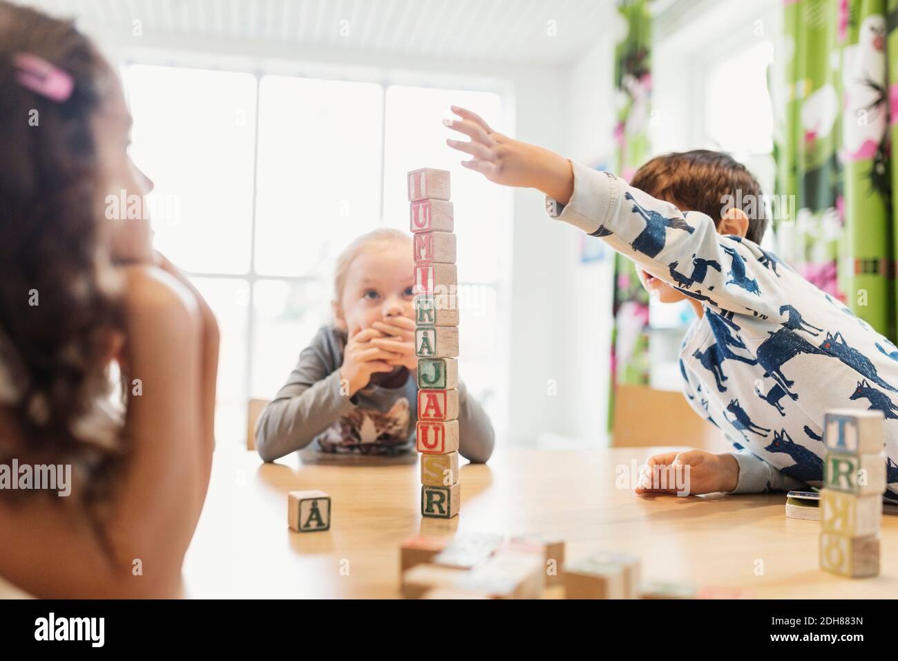 Boy stacking alphabet blocks on table Stock Photo - Alamy