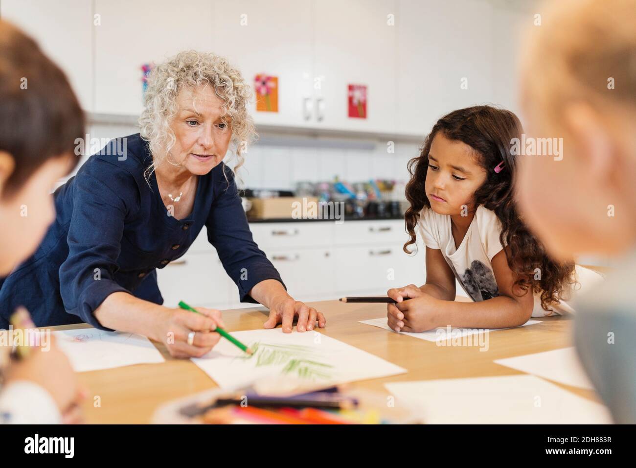 Senior teacher with students in drawing class Stock Photo - Alamy