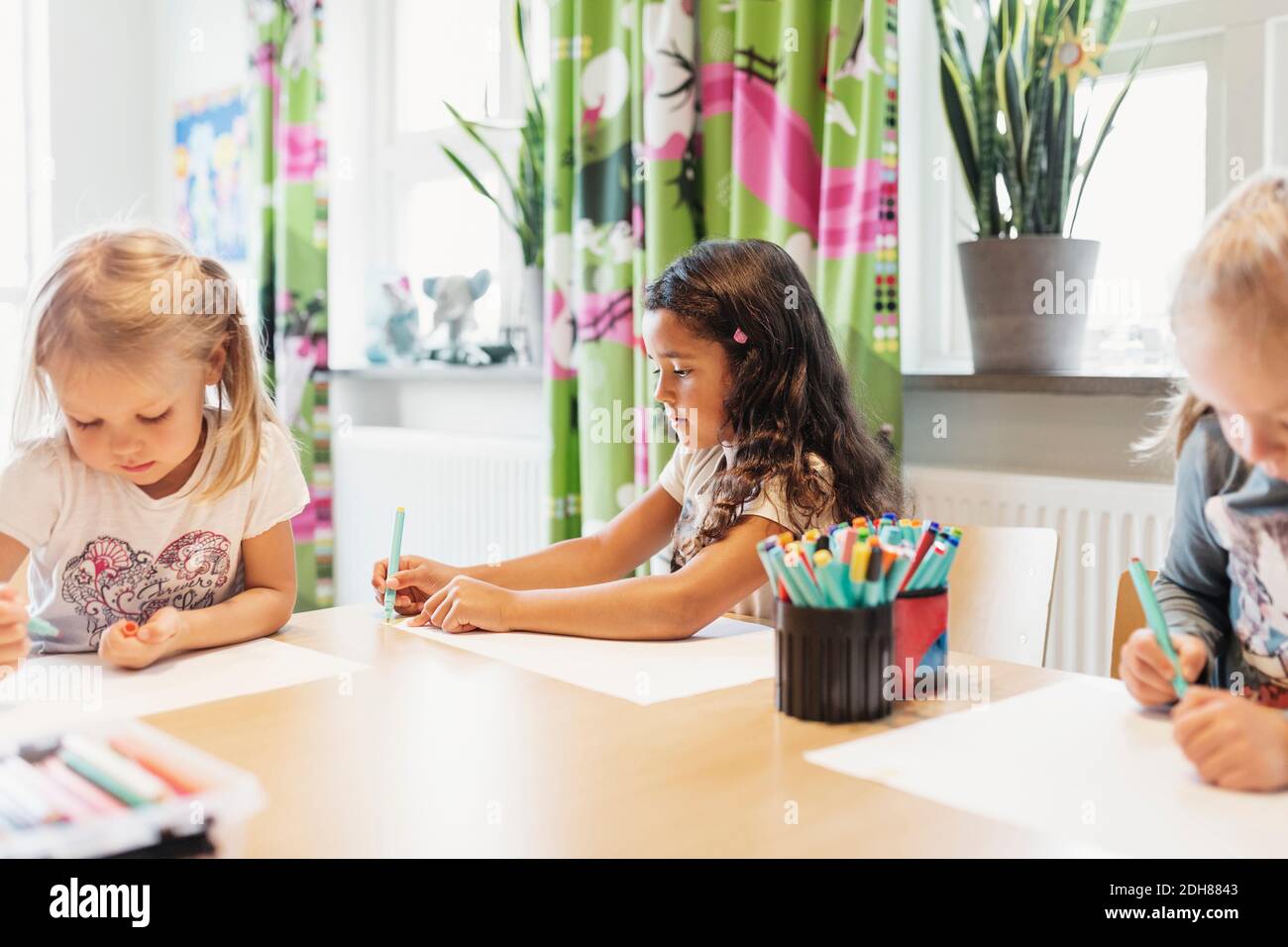 Female students drawing at table in classroom Stock Photo - Alamy
