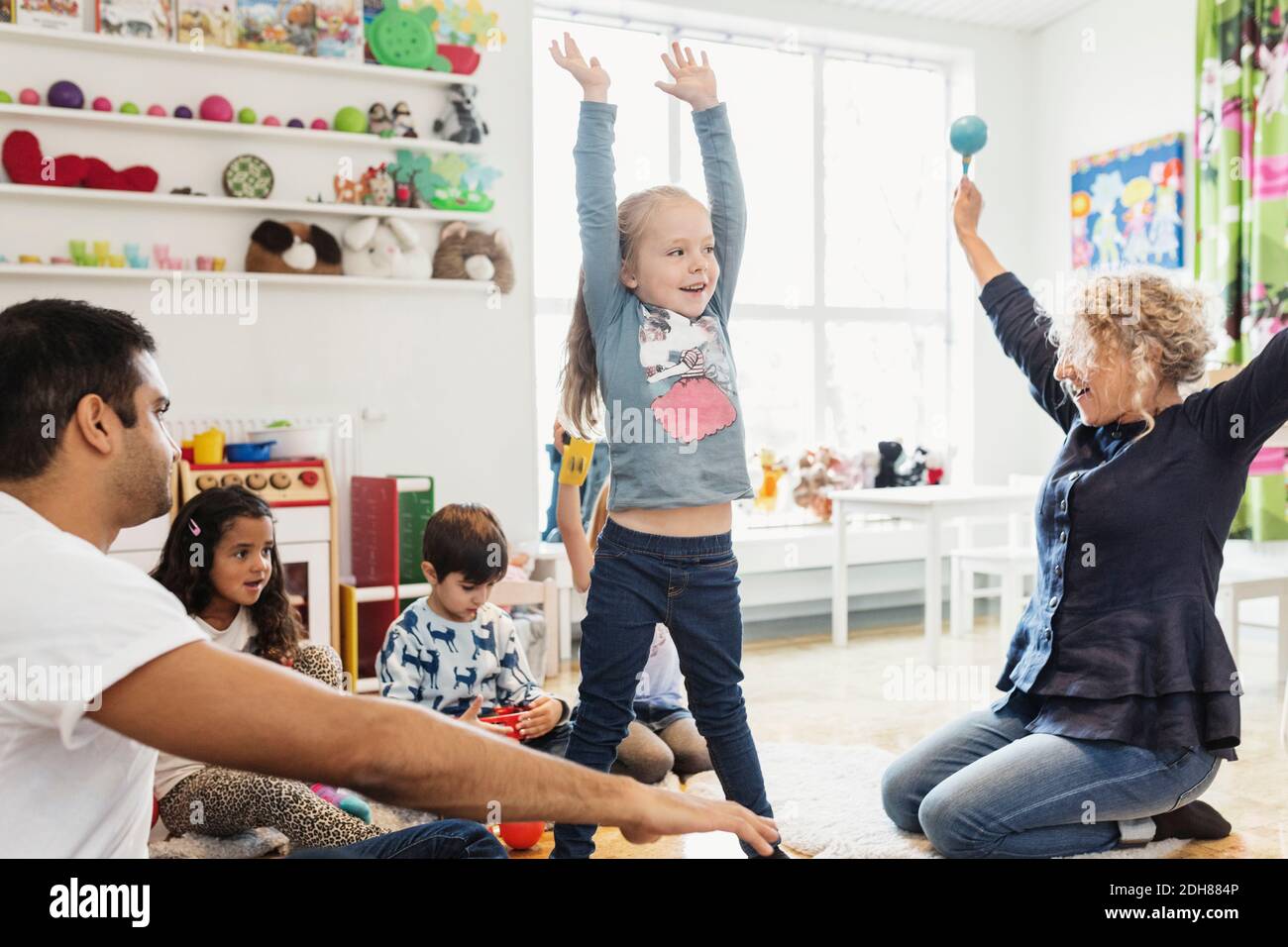 Happy girl dancing while teachers and friends sitting in classroom ...