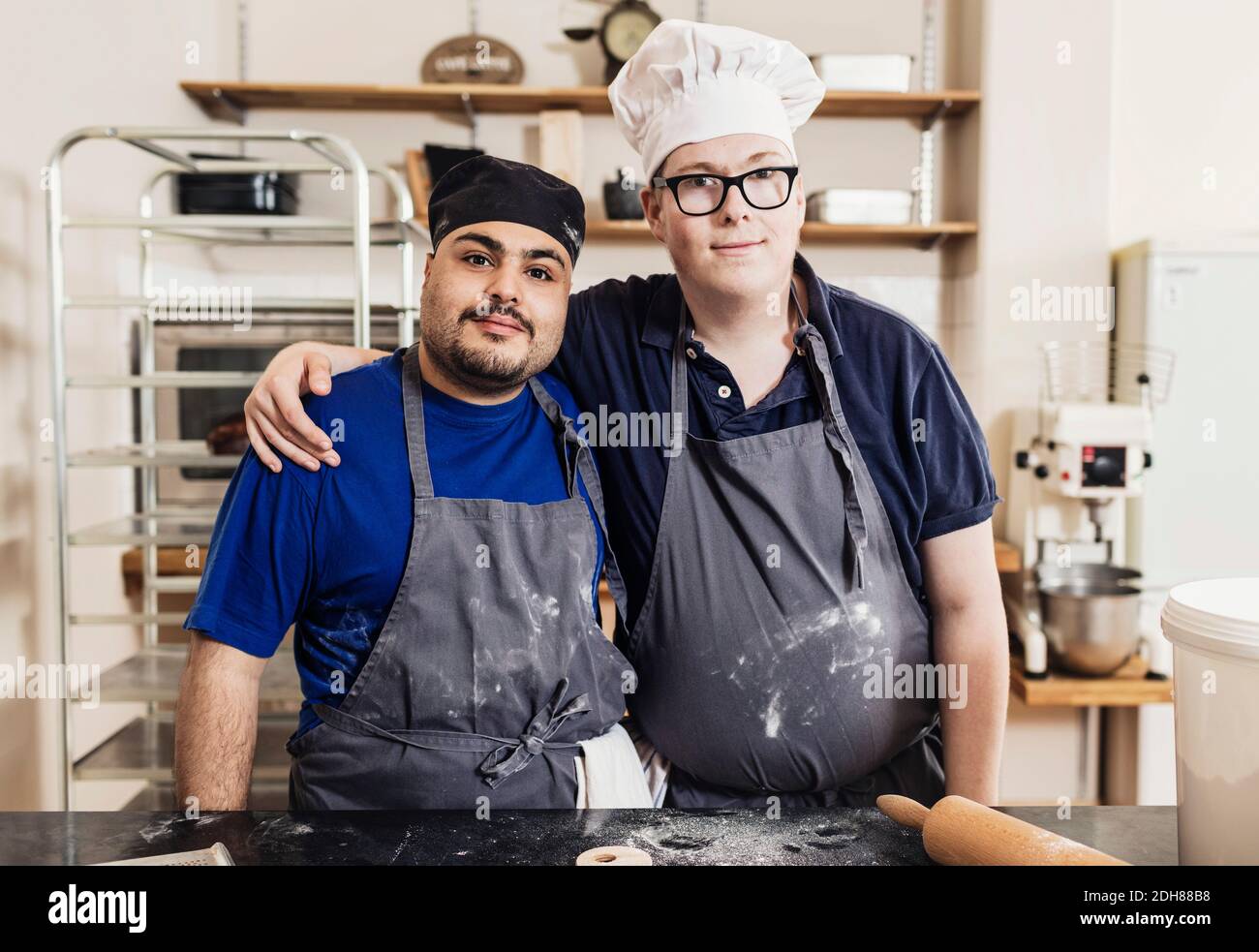 Portrait of bakers standing by table in kitchen Stock Photo - Alamy