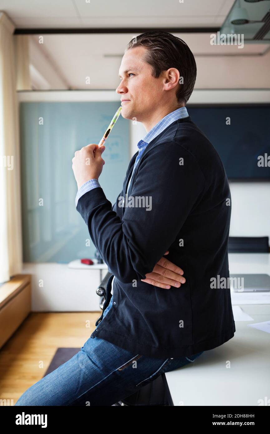 Side view of mid adult man thinking Stock Photo - Alamy
