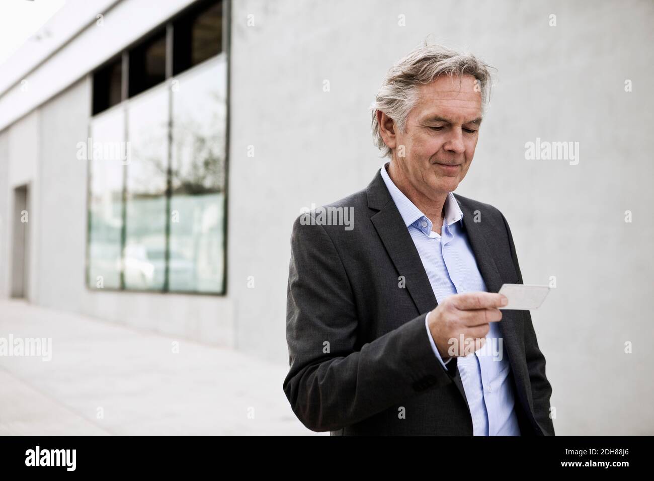 Front view of senior businessman reading card Stock Photo - Alamy