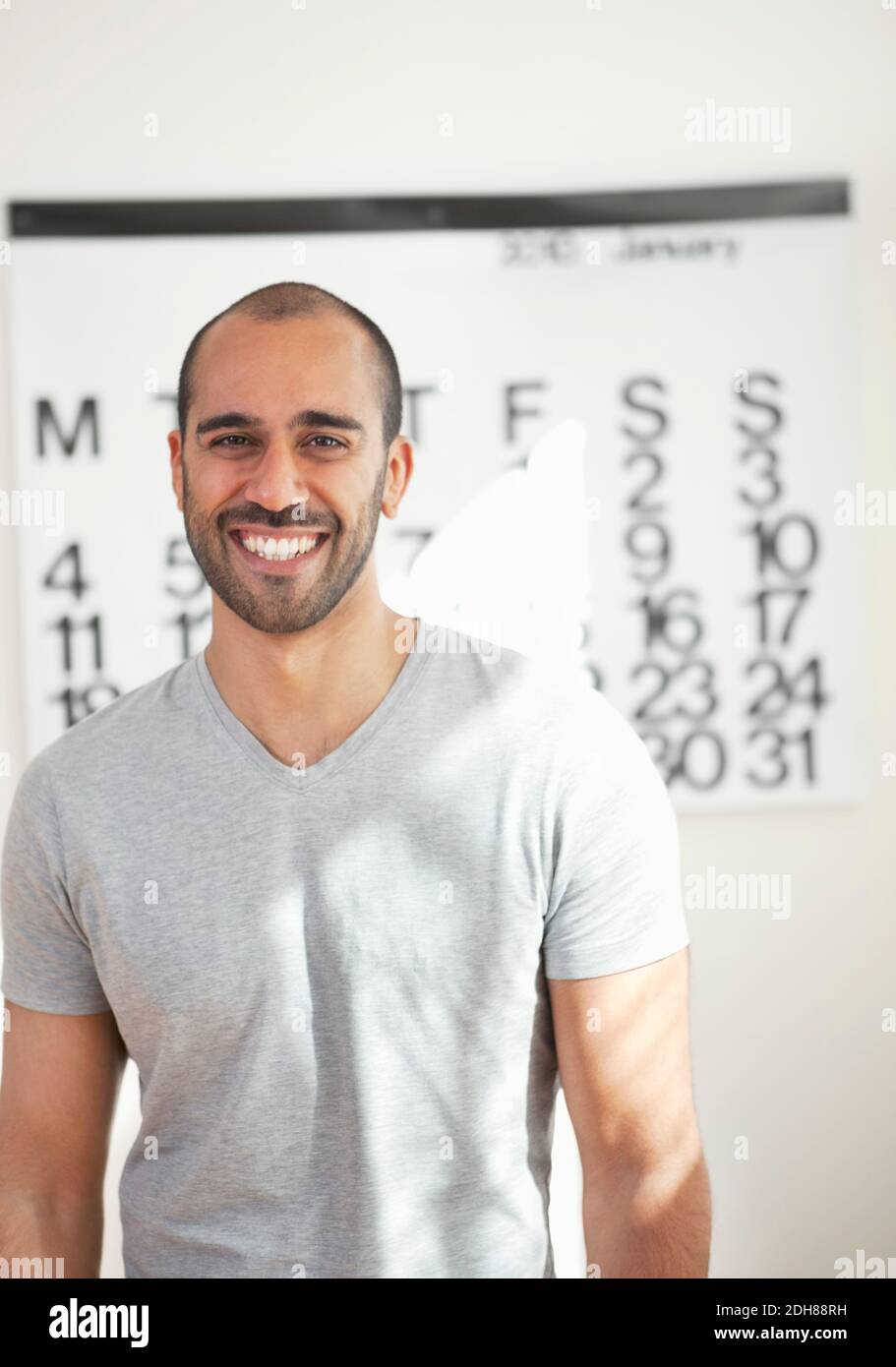 Front view of smiling mid adult man with calendar in behind Stock Photo ...