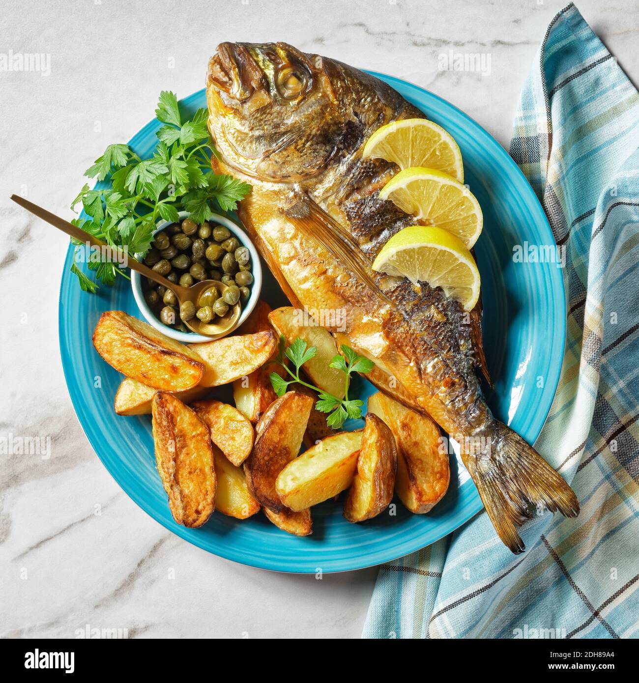 grilled sea bream, orata, dorado fish served on a plate with roasted ...