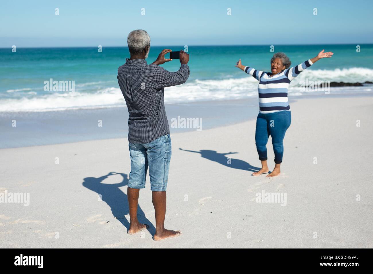 Old couple taking photos at the beach Stock Photo - Alamy