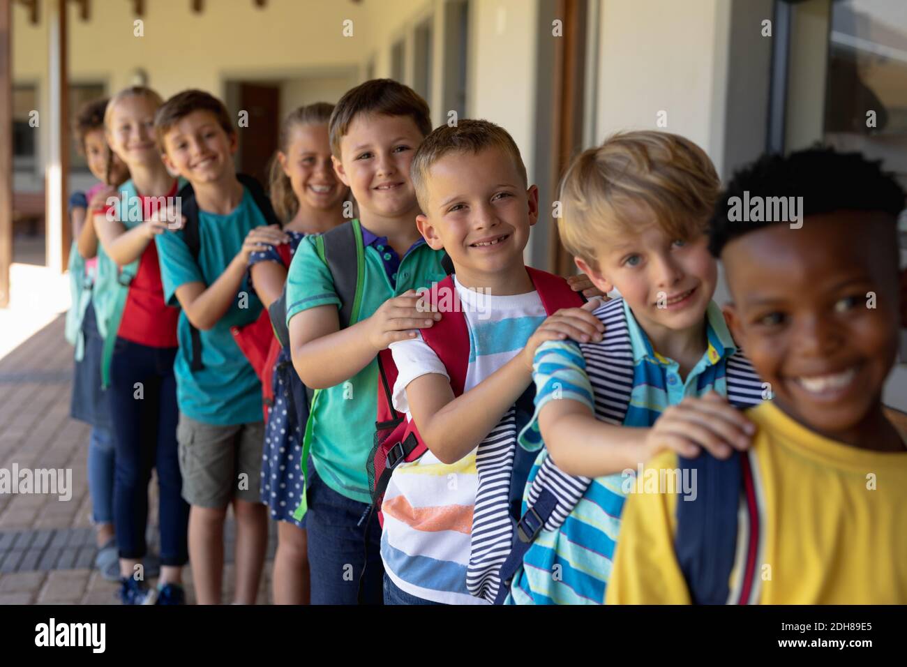 Group of schoolchildren walking single file with hands on each others ...